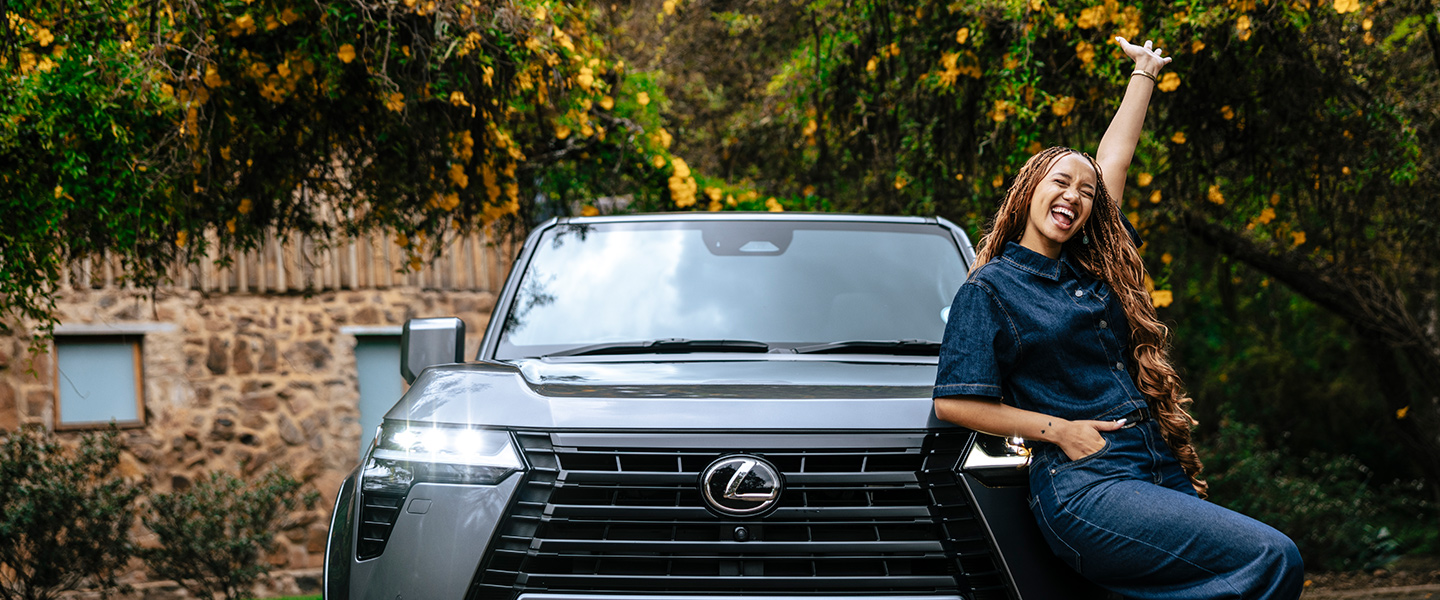 An excited lady next to the Lexus GX SE
